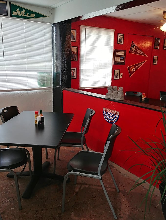 College pennants and vibrant red walls create the perfect backdrop for conversations that inevitably circle back to "how good was that brisket?"