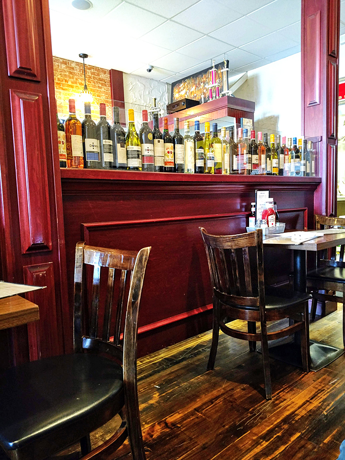 Wine bottles stand at attention like soldiers guarding flavor. The rich wood paneling whispers tales of countless celebrations and first dates.