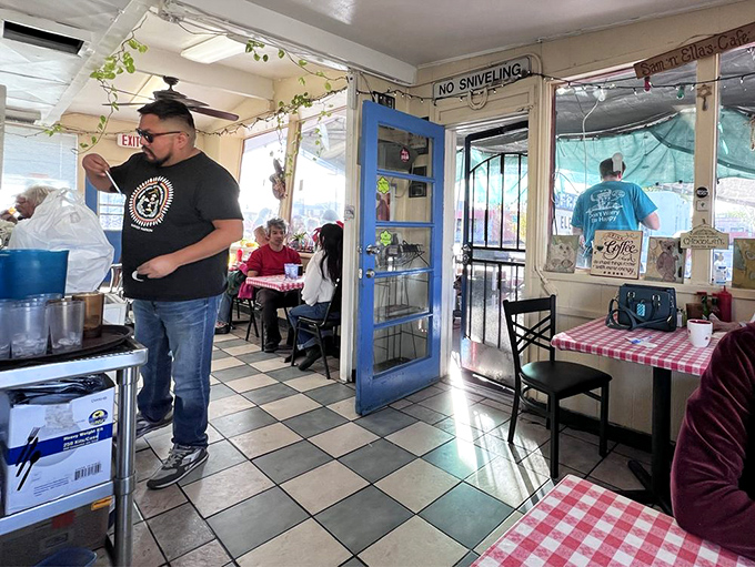 "No Sniveling" warns the sign, as diners enjoy their meals in a space where complaints are rare and satisfaction is guaranteed.