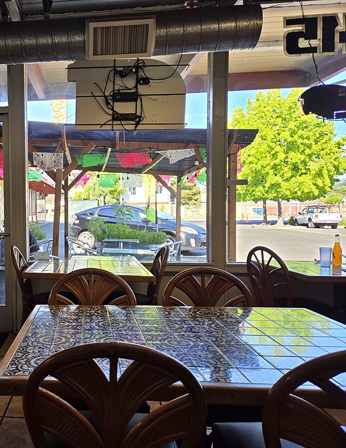 Sunlight streams through windows, illuminating tables that have hosted countless conversations. The tile patterns tell stories while the chairs invite you to add your own.