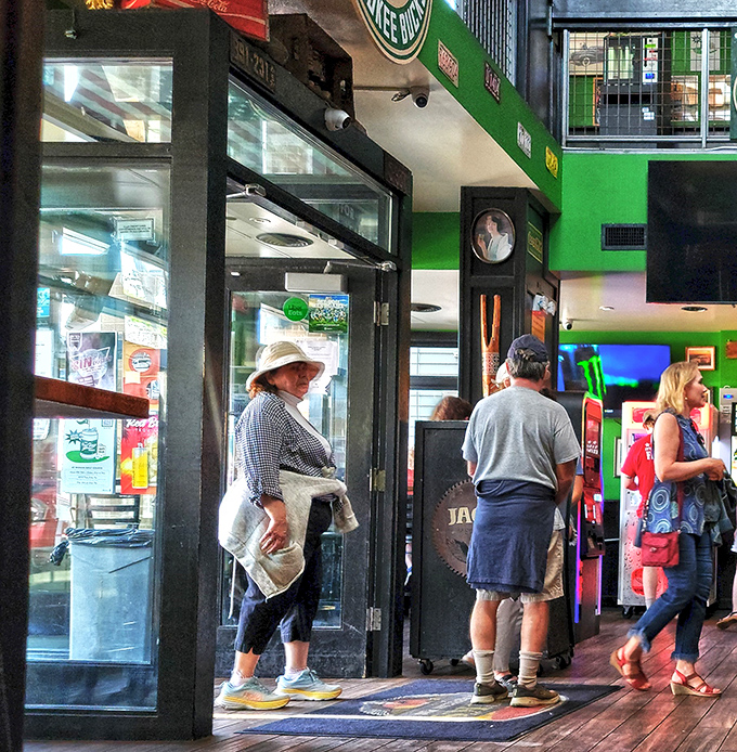 The emerald-hued interior creates a cozy backdrop for conversations that flow as easily as the local craft beers on tap.