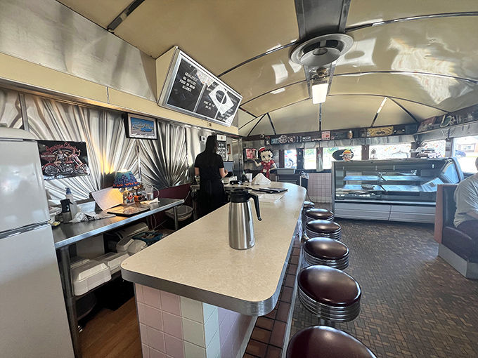 The curved ceiling and row of classic counter stools create the quintessential diner silhouette&mdash;a space where conversations flow as freely as the coffee.