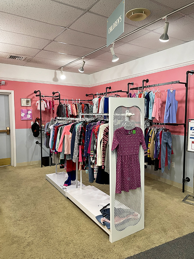 The children's clothing area pops with color against pink walls. Growing kids mean these barely-worn treasures cycle through quickly for savvy parents.