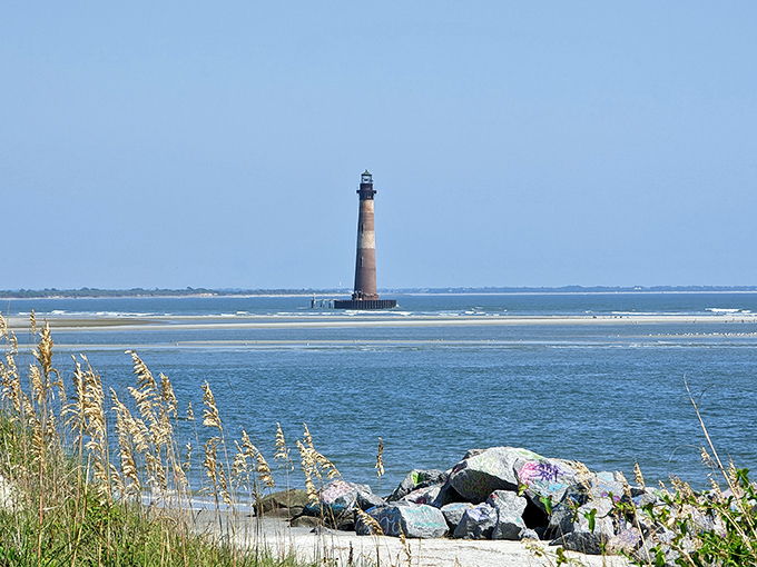 Morris Island Lighthouse stands sentinel over changing tides and times. This weathered guardian has witnessed countless sunrises while keeping silent watch over Folly's shores.