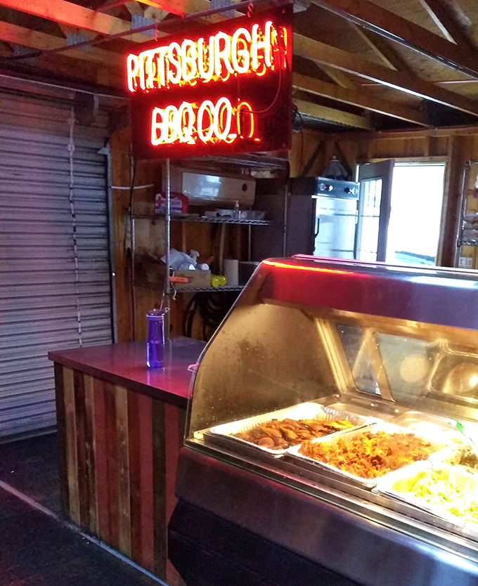 The neon sign glows like a barbecue beacon, illuminating trays of sides waiting for their meaty companions. This counter is where dreams and dinner plates come together.