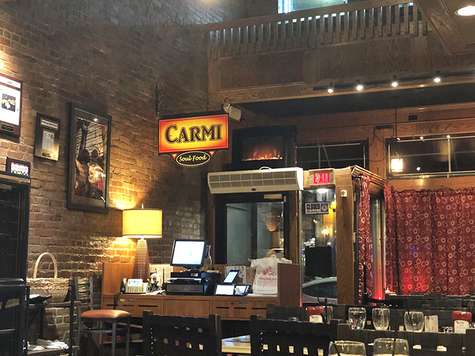 Warm lighting against exposed brick creates that "welcome home" feeling before you've even ordered. The sign promises soul food satisfaction.