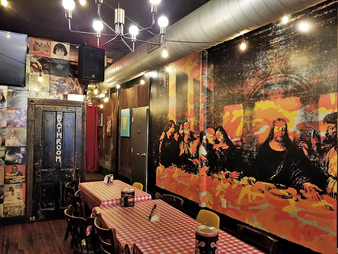 Black leather booths and warm lighting create intimate spaces where friends gather to debate life's important questions.