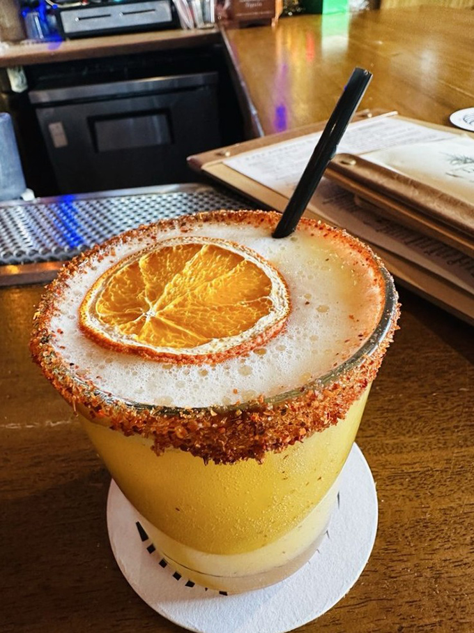 This isn't just a margarita—it's liquid sunshine with attitude. That tajin rim isn't messing around, and neither should you when ordering.