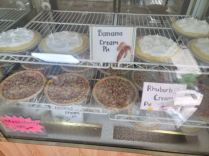A display case of cream pies that makes choosing just one a Sophie's Choice of desserts. The banana cream looks particularly ready for its close-up.