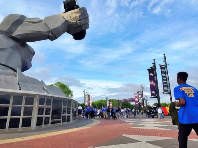 "Just hanging out with my race car." Miles's casual pose belies the engineering marvel of suspending a full-sized vehicle in his concrete grip.