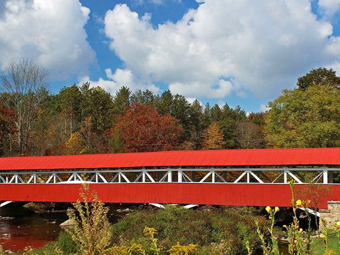 The bridge stretches across the water like a crimson ribbon amid fall foliage. Engineering and aesthetics rarely come together this beautifully.