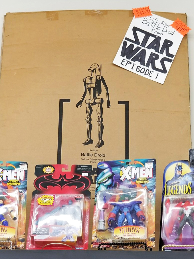 A Star Wars battle droid box surrounded by superhero figures&mdash;childhood dreams preserved in plastic, ready for new adventures.