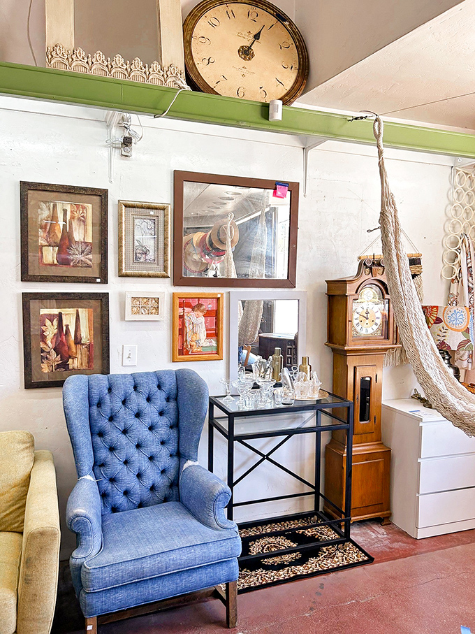 That blue wingback chair isn't just furniture—it's the throne you never knew you needed, complete with its own royal court of vintage accessories.