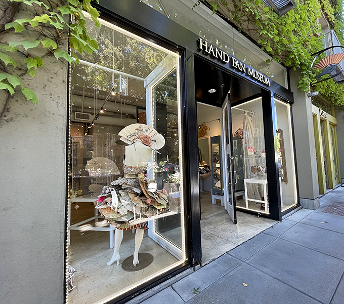 Elegant fans displayed in the window hint at the sophisticated collection of cooling artistry within.