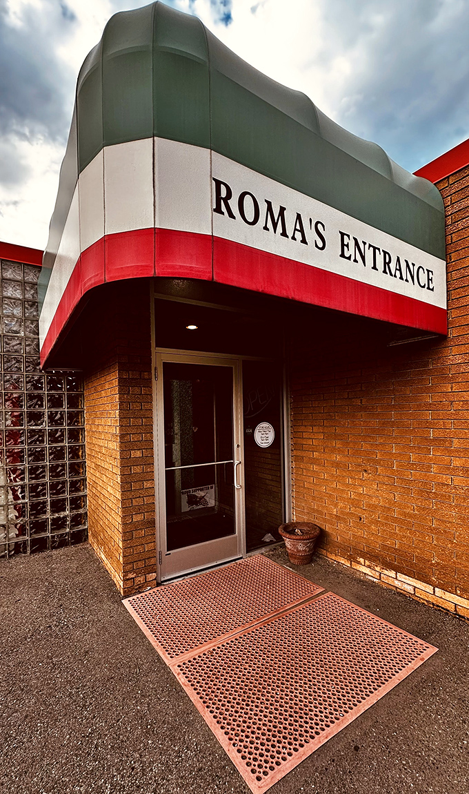Roma's entrance wears Italy's colors proudly. That awning is like a portal transporting you straight to authentic pizza paradise.