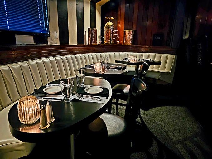 Cream-colored booths against dark wood paneling create the kind of intimate dining alcoves where proposals happen and anniversaries are celebrated.