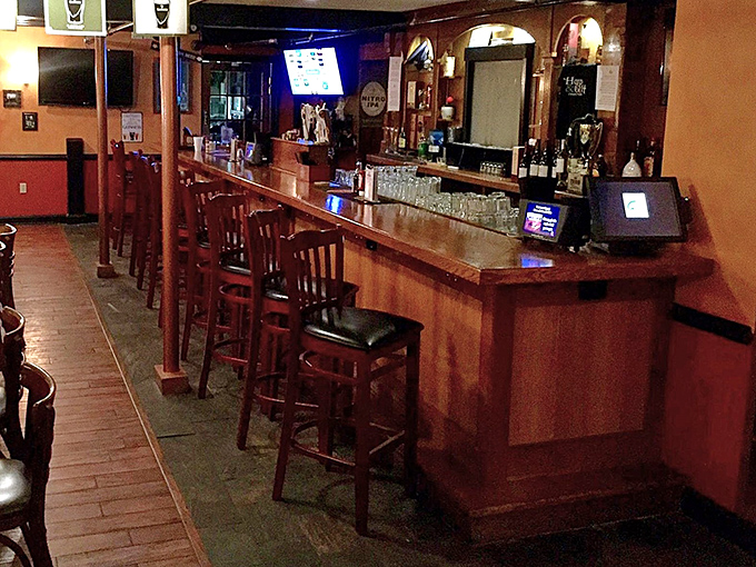 The bar stretches invitingly, promising perfectly poured pints of Guinness and whiskey wisdom from bartenders who know their Irish spirits.