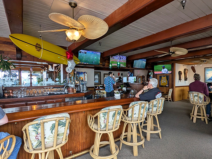 The bar area combines sports-watching comfort with tropical flair – perfect for solo diners or those waiting for tables.