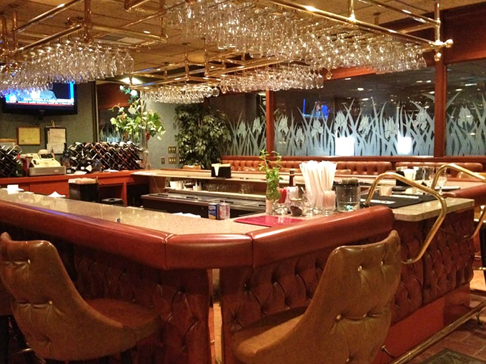 The bar area gleams with promise, where stemware hangs like crystal stalactites and conversations flow as smoothly as the drinks.