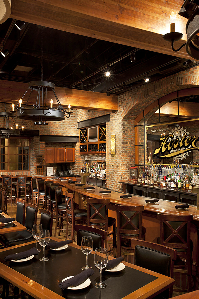 The bar area combines rustic charm with sophisticated service&mdash;where strangers become friends over perfectly poured drinks and shared appetizers.