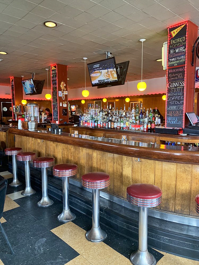 The bar stretches like a wooden rainbow, offering liquid courage for your boldest topping experiments.