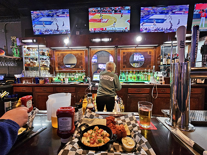 The bar area welcomes both solo diners and groups seeking cold drinks with hot wings.