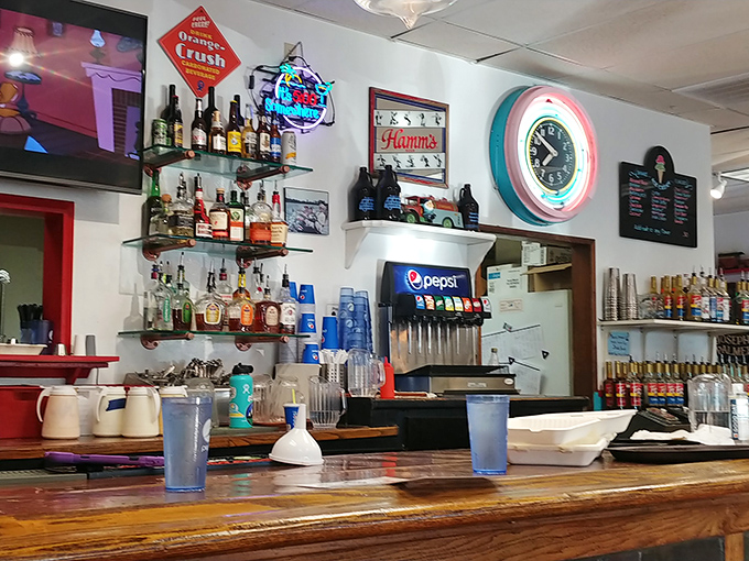 The bar area isn't trying to be trendy—it's confidently classic with its neon clock and vintage signs that say "stay awhile."