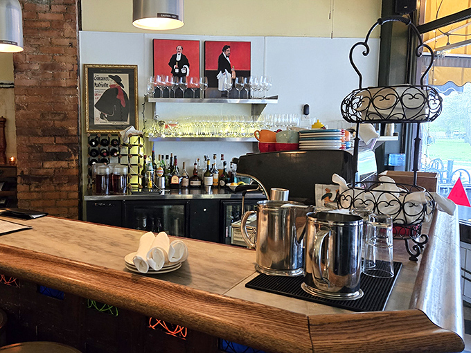 The bar area whispers of aperitifs and digestifs, where bottles stand like soldiers ready to enhance your meal. French posters nod knowingly from the walls.