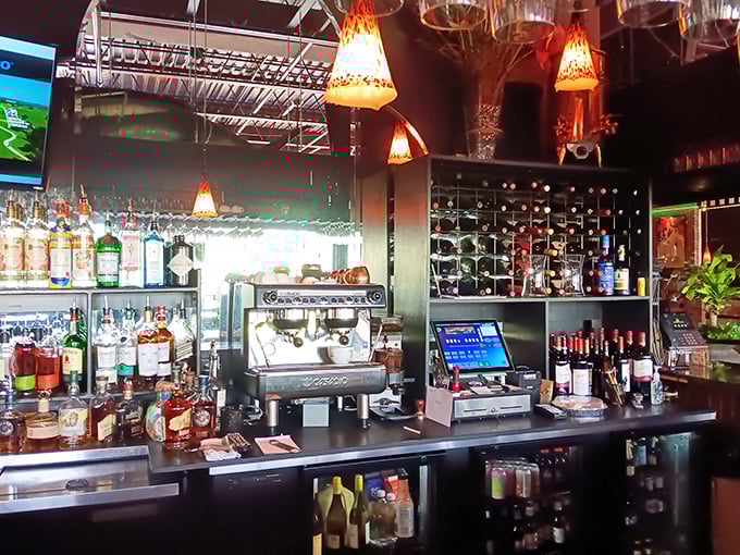 A bar stocked with possibilities, where skilled mixologists transform premium spirits into liquid joy. Those pendant lights cast the perfect glow for evening indulgence.