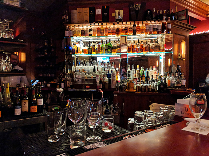 A bar stocked like a liquid library of happiness. The illuminated shelves showcase bottles like rare books, each telling its own story.
