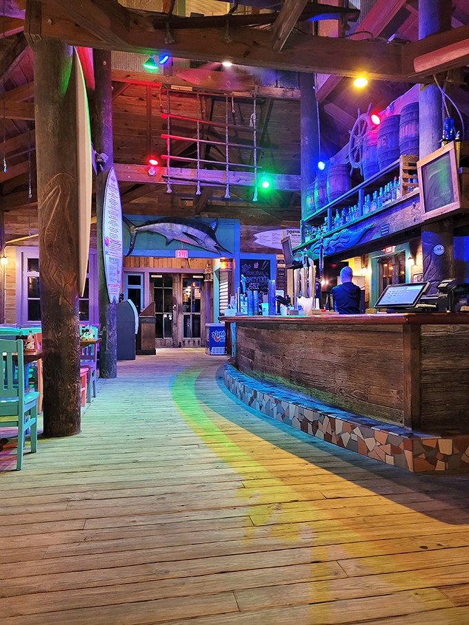 The bar glows with promise as evening falls, a beacon of tropical cocktails and seafood dreams under the weathered wooden beams.