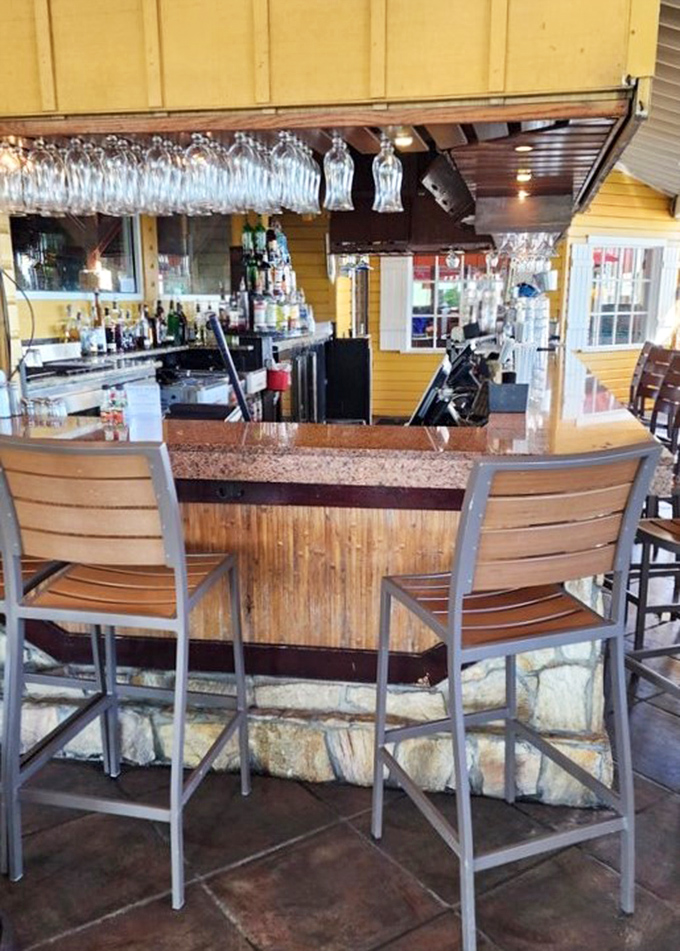 An outdoor bar where hanging glasses catch the light like crystal wind chimes, and bartenders craft liquid vacations one cocktail at a time.