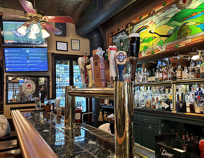 Behind every great pub is a bar that tells stories. This one speaks volumes with its gleaming taps and stained glass backdrop.
