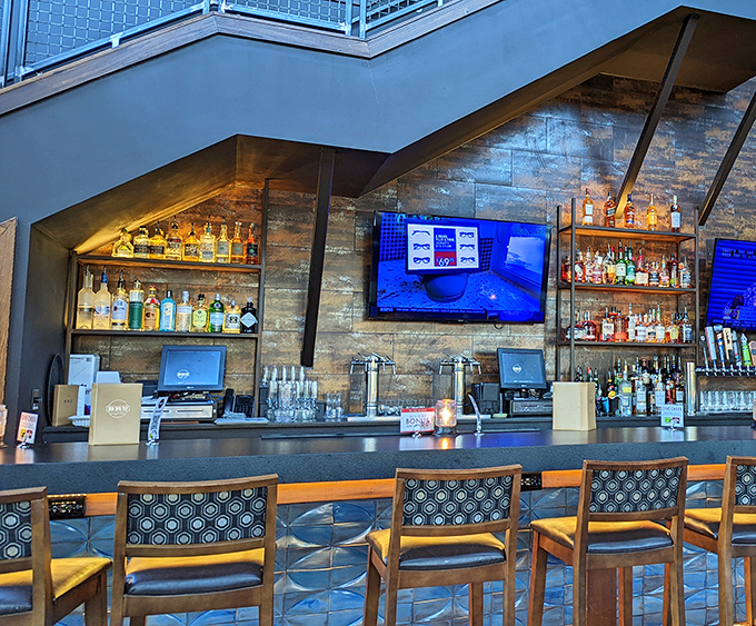 The bar area gleams with promise, bottles backlit like treasures in a museum dedicated to the art of liquid happiness.