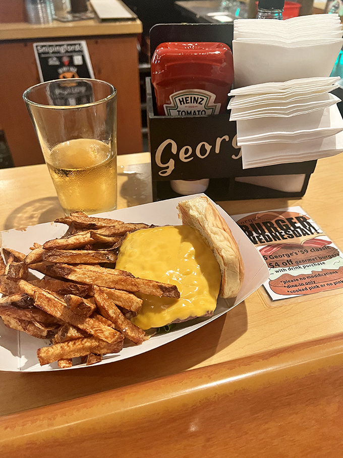 The holy trinity of tavern happiness: cold beer, hot burger, and hand-cut fries. Notice how the cheese drapes over the patty like a cozy yellow blanket. 