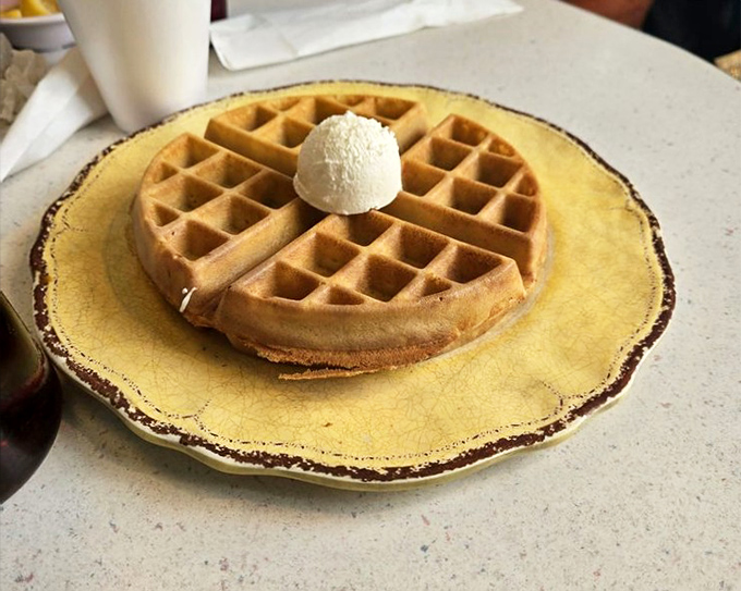 Belgian waffles standing tall and proud, topped with ice cream because sometimes breakfast needs a victory lap.