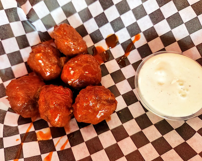 Buffalo wings served on checkered paper—proof that sometimes the simplest presentations deliver the most profound flavor experiences.