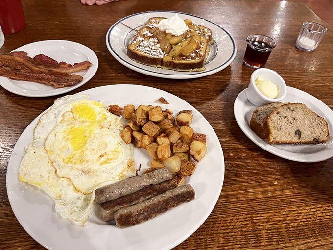 The breakfast trinity: perfectly fried eggs, golden home fries, and sausage links &ndash; a plate that says "good morning" in the most delicious language.