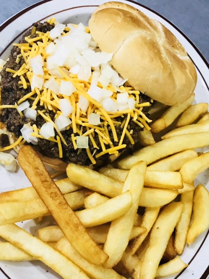 A burger that demands to be noticed, crowned with cheese and onions, with fries standing at attention alongside.