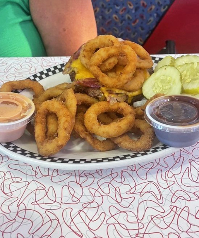 A burger crowned with onion rings isn't excess&mdash;it's ambition. Those pickle slices stand guard like sentinels of tang against the richness.