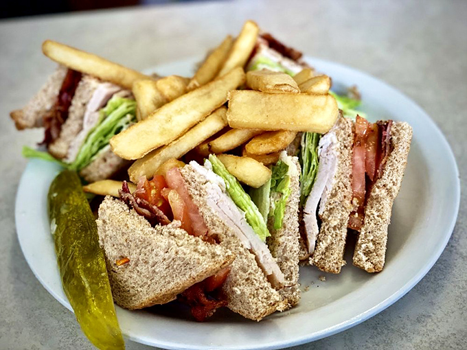 The club sandwich&mdash;three stories of delicious architecture where every floor houses something wonderful, with a pickle doorman standing guard.