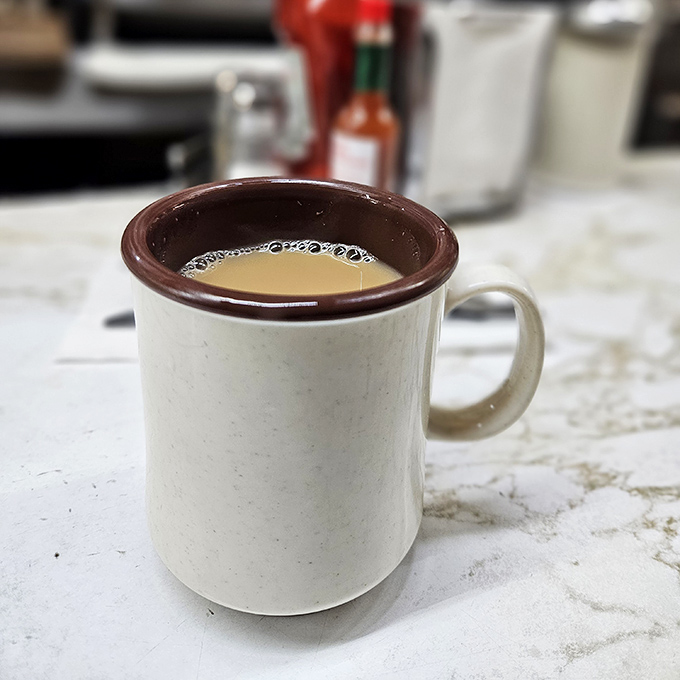 That coffee mug has seen things. The brown rim tells stories of thousands of refills and countless early morning conversations.