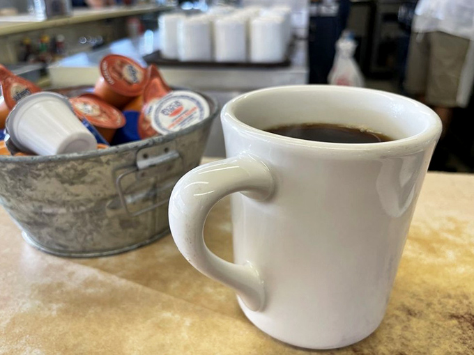 Coffee in a mug thick enough to withstand nuclear winter, served alongside cream that hasn't been overthinking its role in society.