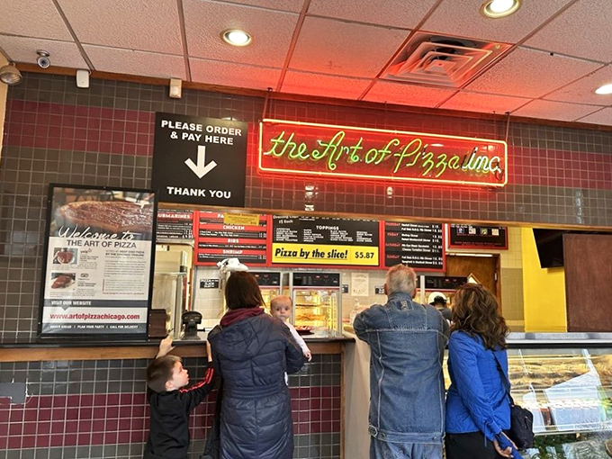 The ordering counter, where pizza dreams begin their journey to reality. That neon sign promises artistry, not just food.