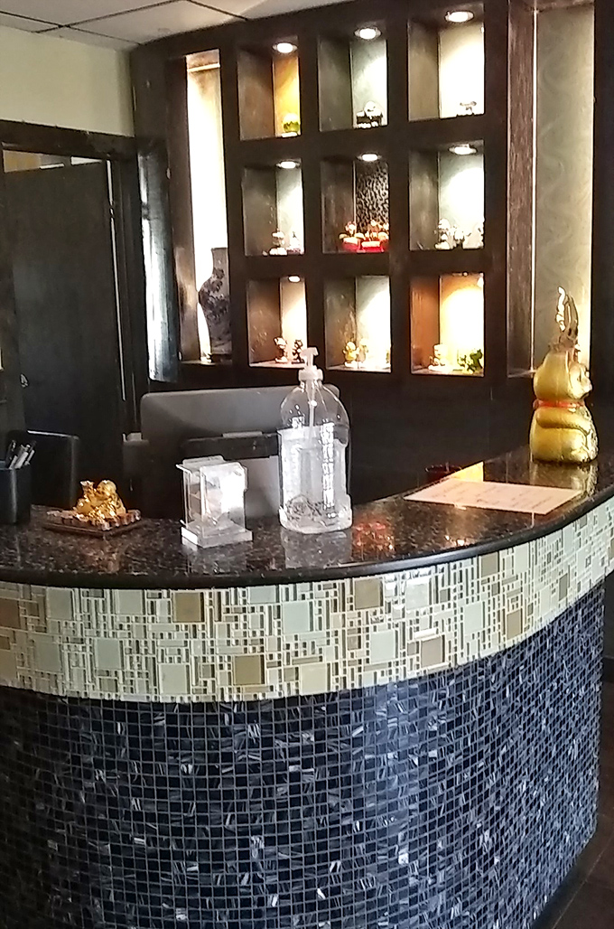 The reception counter, adorned with display niches and mosaic tiles, offers the first hint that Joy Luck cares about details beyond just filling plates.