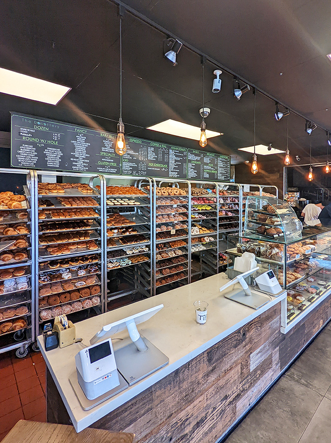 Behind this counter, donut magic happens daily, with racks that would make Willy Wonka consider a career change.