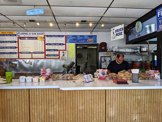 Behind this counter, sandwich artisans perform their daily magic, transforming simple ingredients into legendary meals.