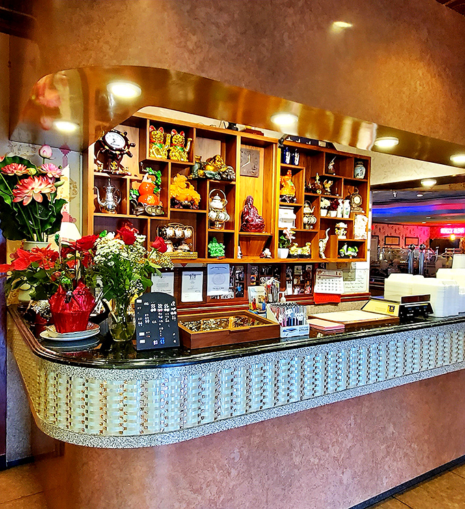 The ornate reception counter, adorned with decorative figurines and fresh flowers, sets the tone for the experience that awaits.