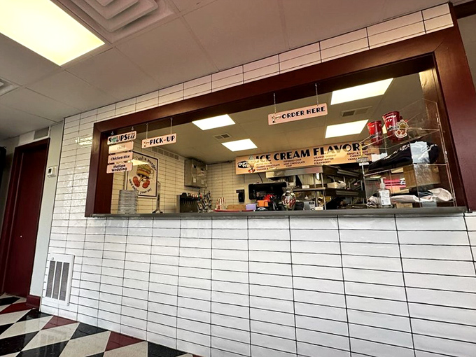 The ordering counter&mdash;where dreams are placed and fulfilled. White subway tiles gleam with the promise of ice cream flavors to come.