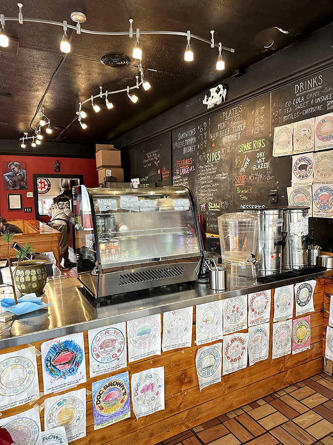 The counter where dreams come true, adorned with colorful plates that tell the story of barbecue pilgrimages past.